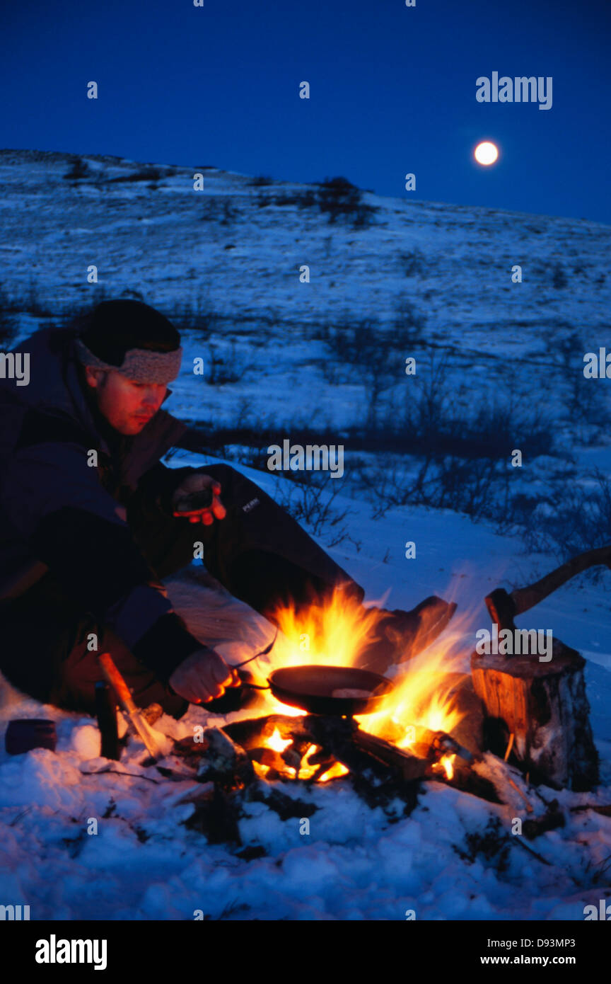 Man sitting near fire Stock Photo - Alamy