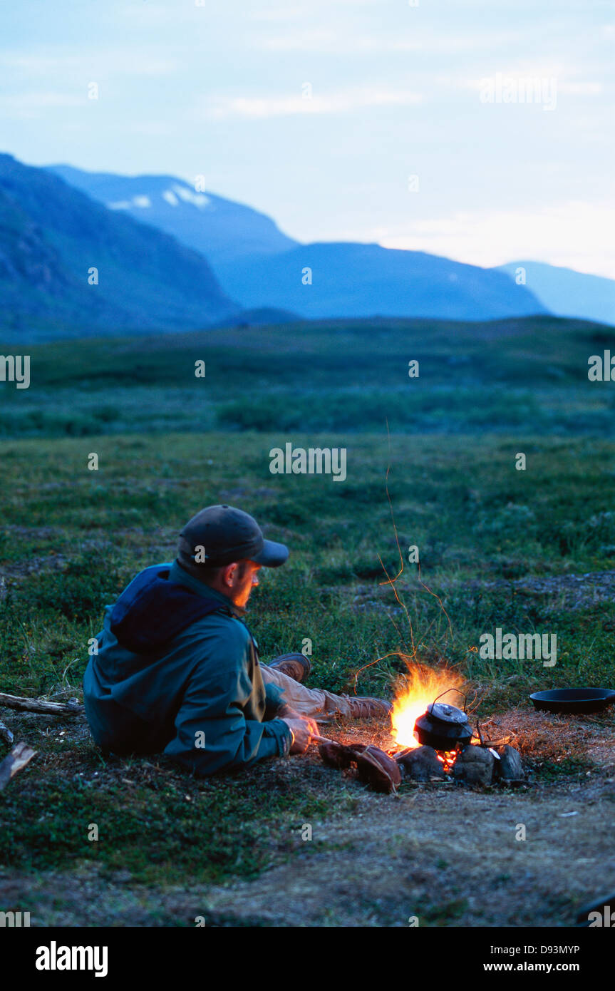 Man sitting near fire Stock Photo - Alamy