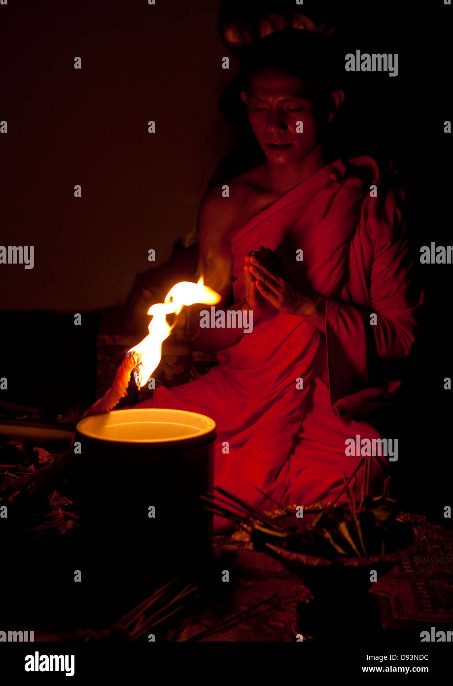 Monk Praying In Front Of A Fire, Luang Prabang, Laos Stock Photo - Alamy