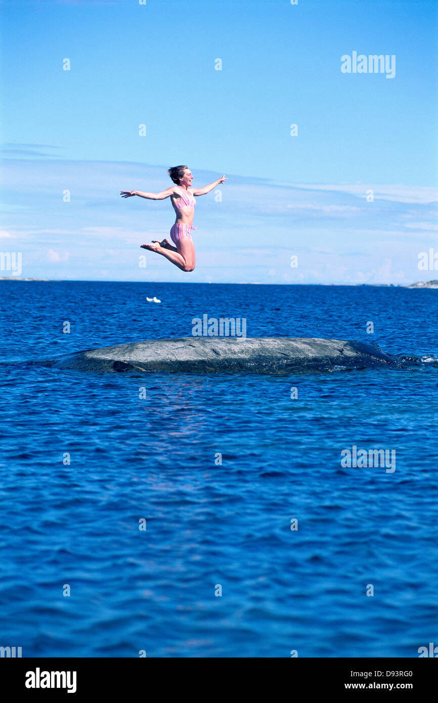 A woman jumping in the sea Stock Photo - Alamy
