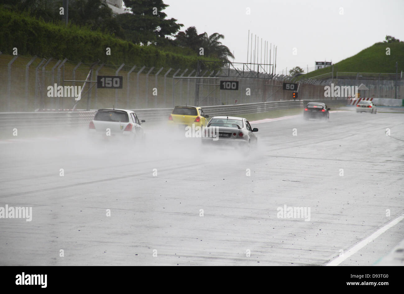 Speeding race cars approaching the sharp corner of a racing circuit ...