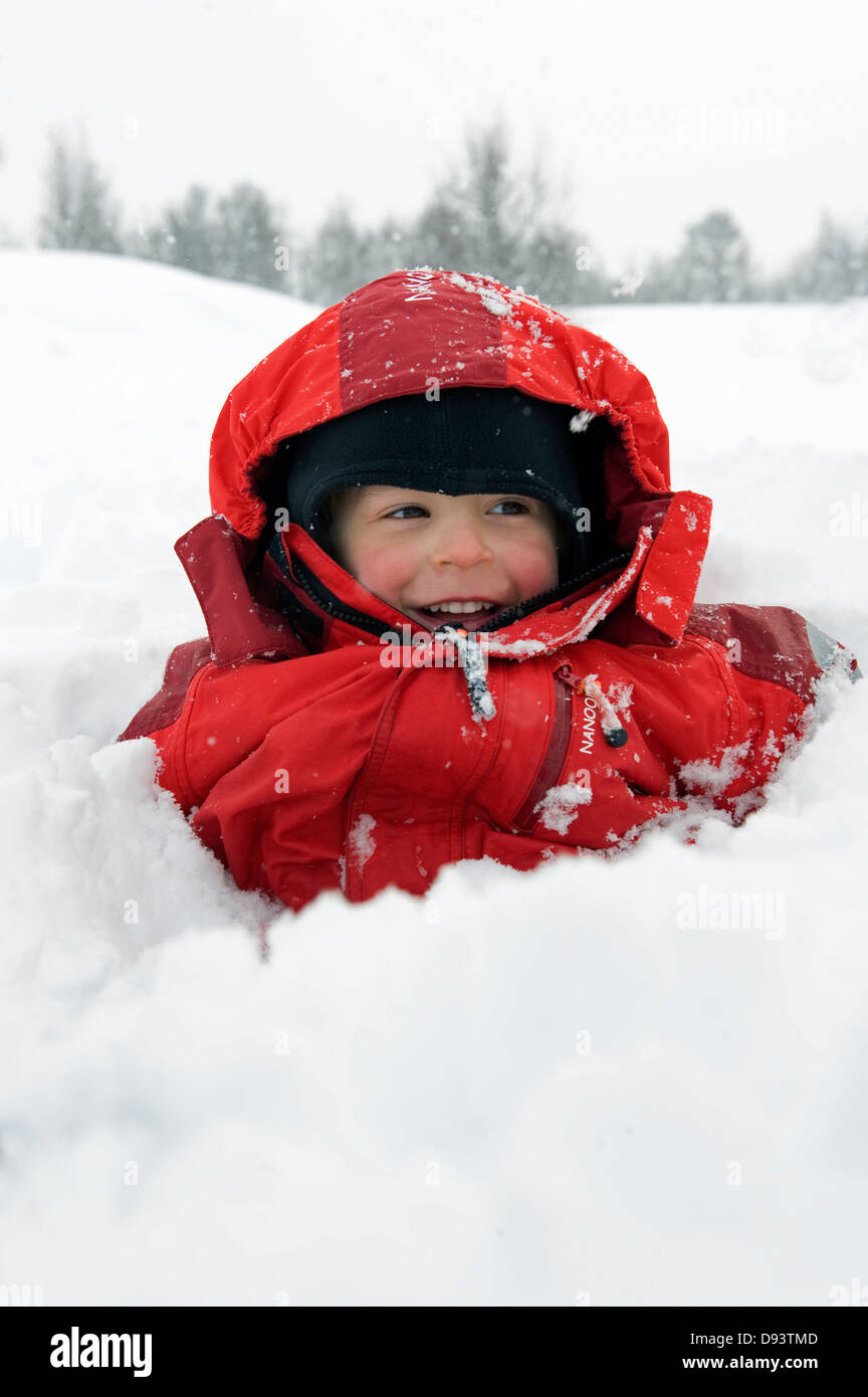 Boy being buried in snow Stock Photo - Alamy