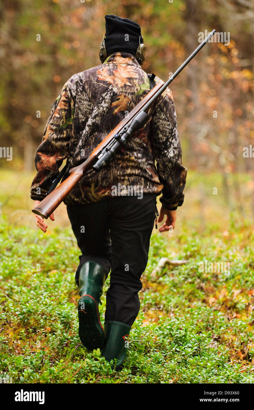 Hunter walking in forest Stock Photo - Alamy