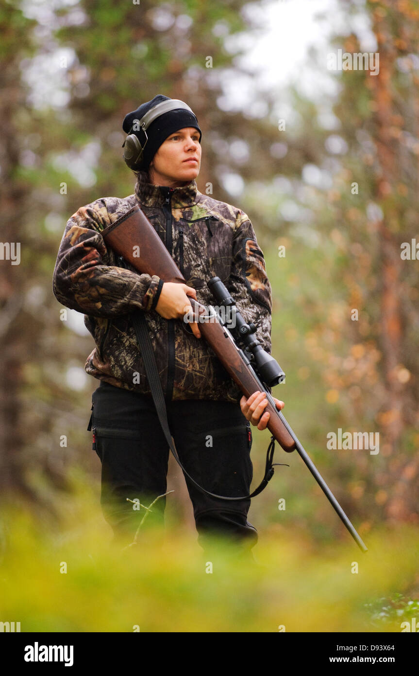 Hunter holding rifle in forest and looking away, low angle view Stock ...