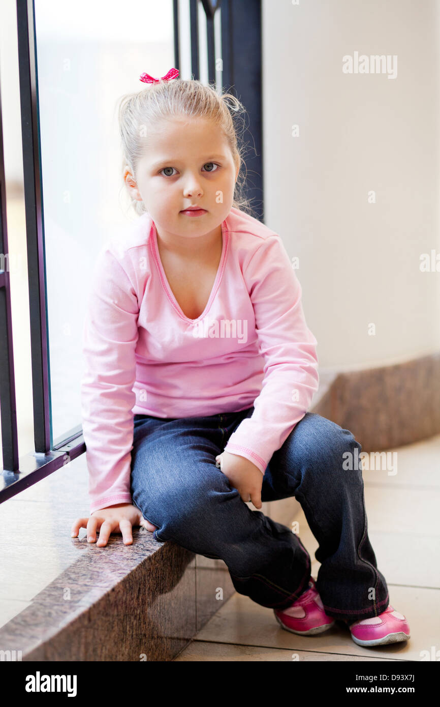 cute little girl sitting by window Stock Photo - Alamy
