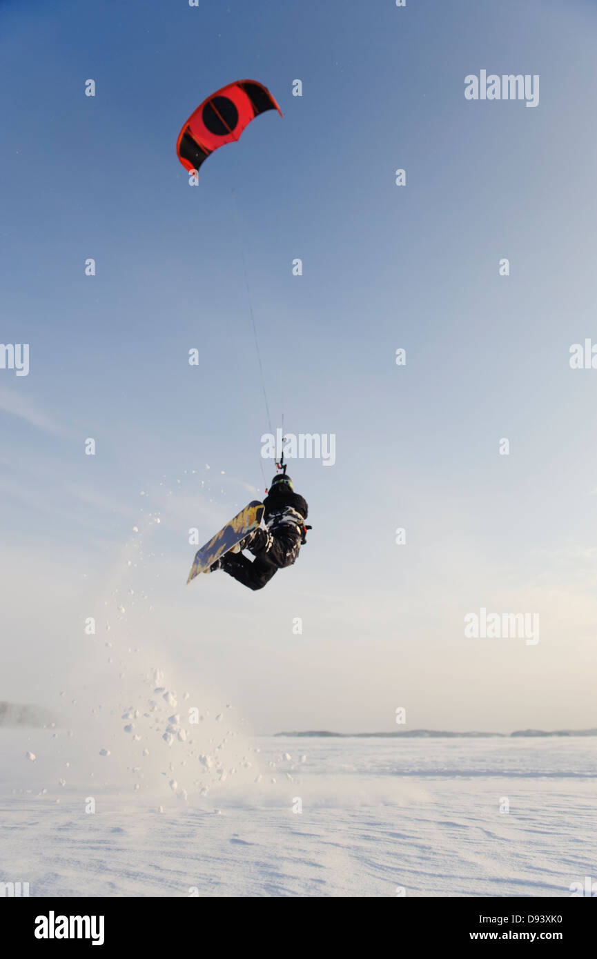 Man jumping in mid air while kiteboarding in snow Stock Photo - Alamy