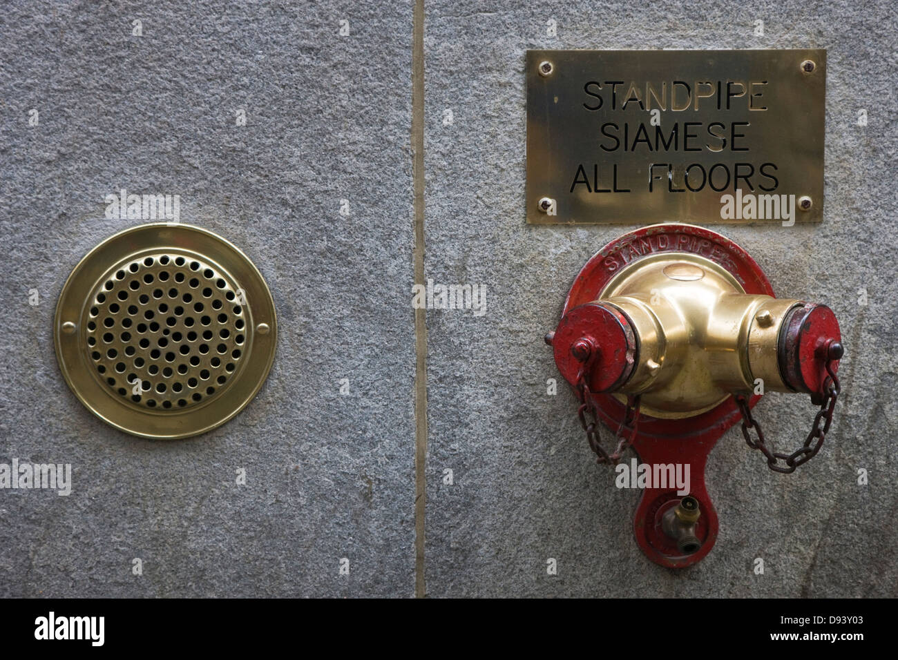 Double headed fire hydrant on wall, close-up Stock Photo - Alamy