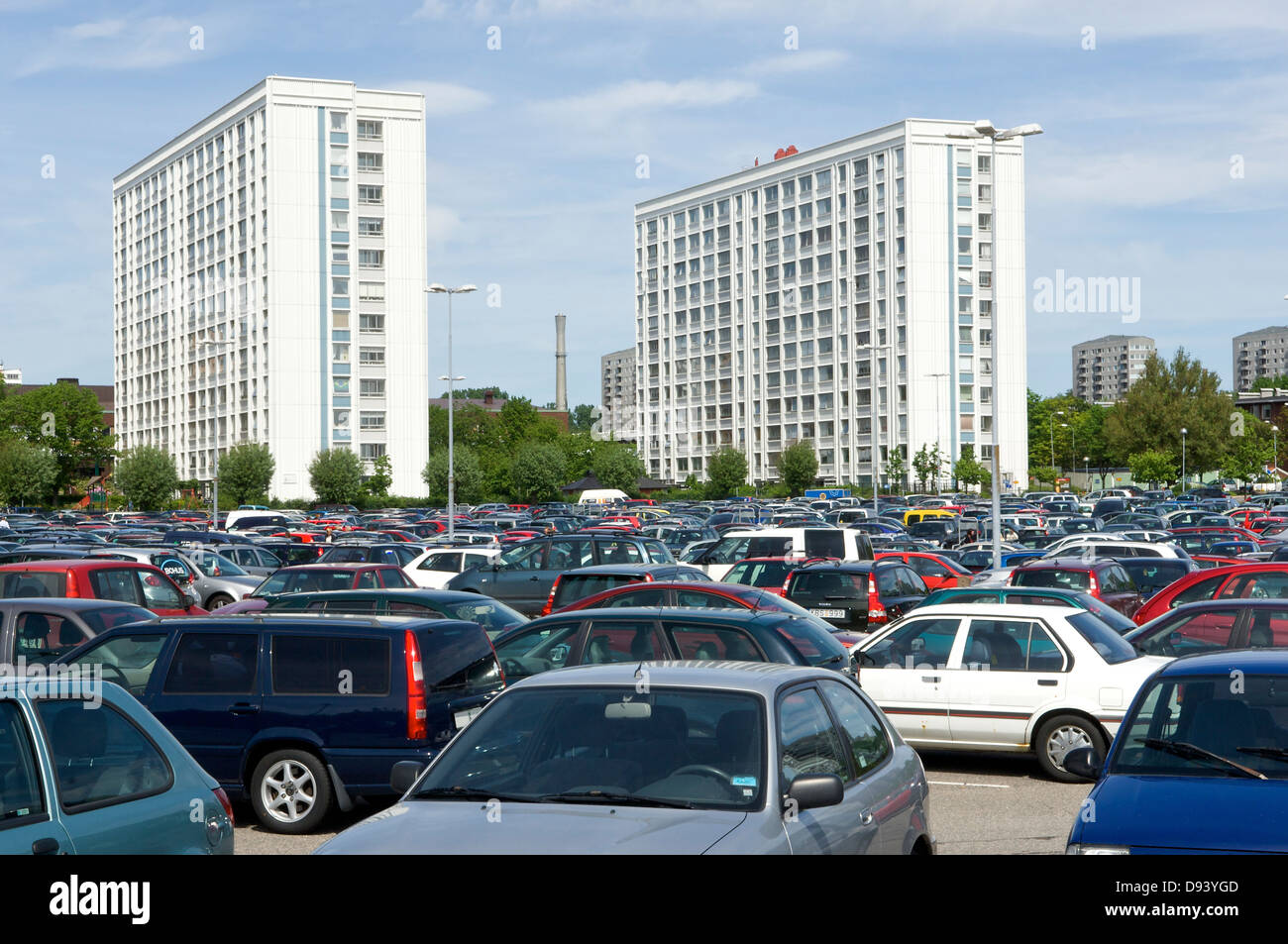 Cars on parking lot wit high rise apartment buildings in background ...