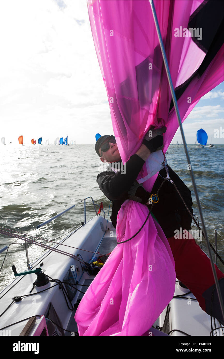 Man folding sail during yacht racing Stock Photo - Alamy
