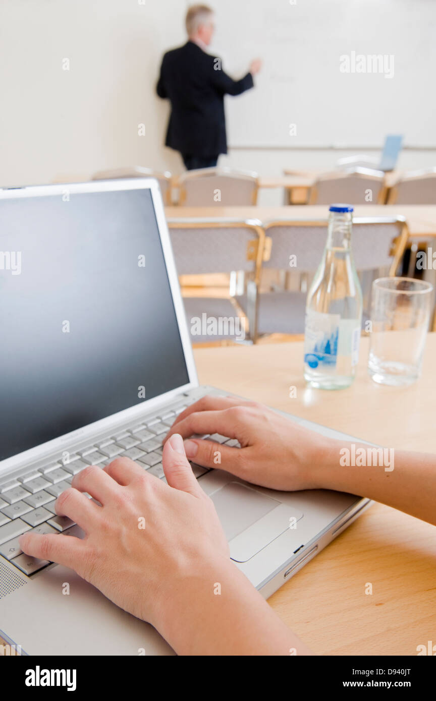 Student typing on laptop in classroom Stock Photo - Alamy