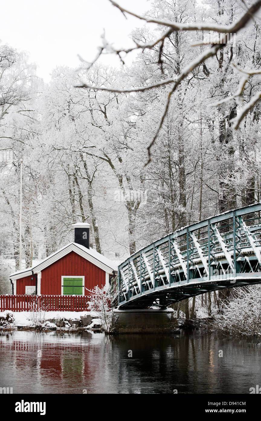 Cottage by river with footbridge Stock Photo - Alamy