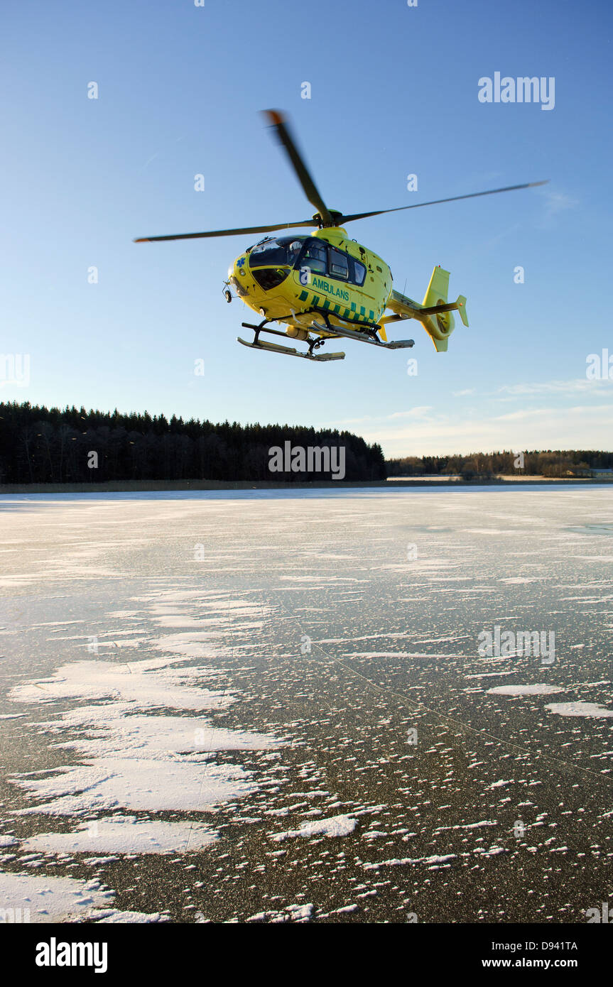 Medical rescue helicopter flying over frozen river Stock Photo - Alamy
