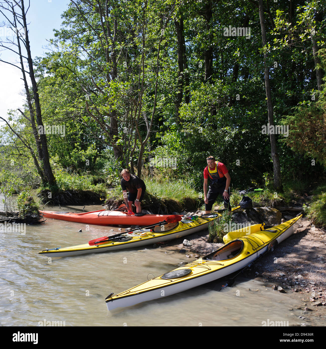 Two men with kayaks at a beach Stock Photo - Alamy