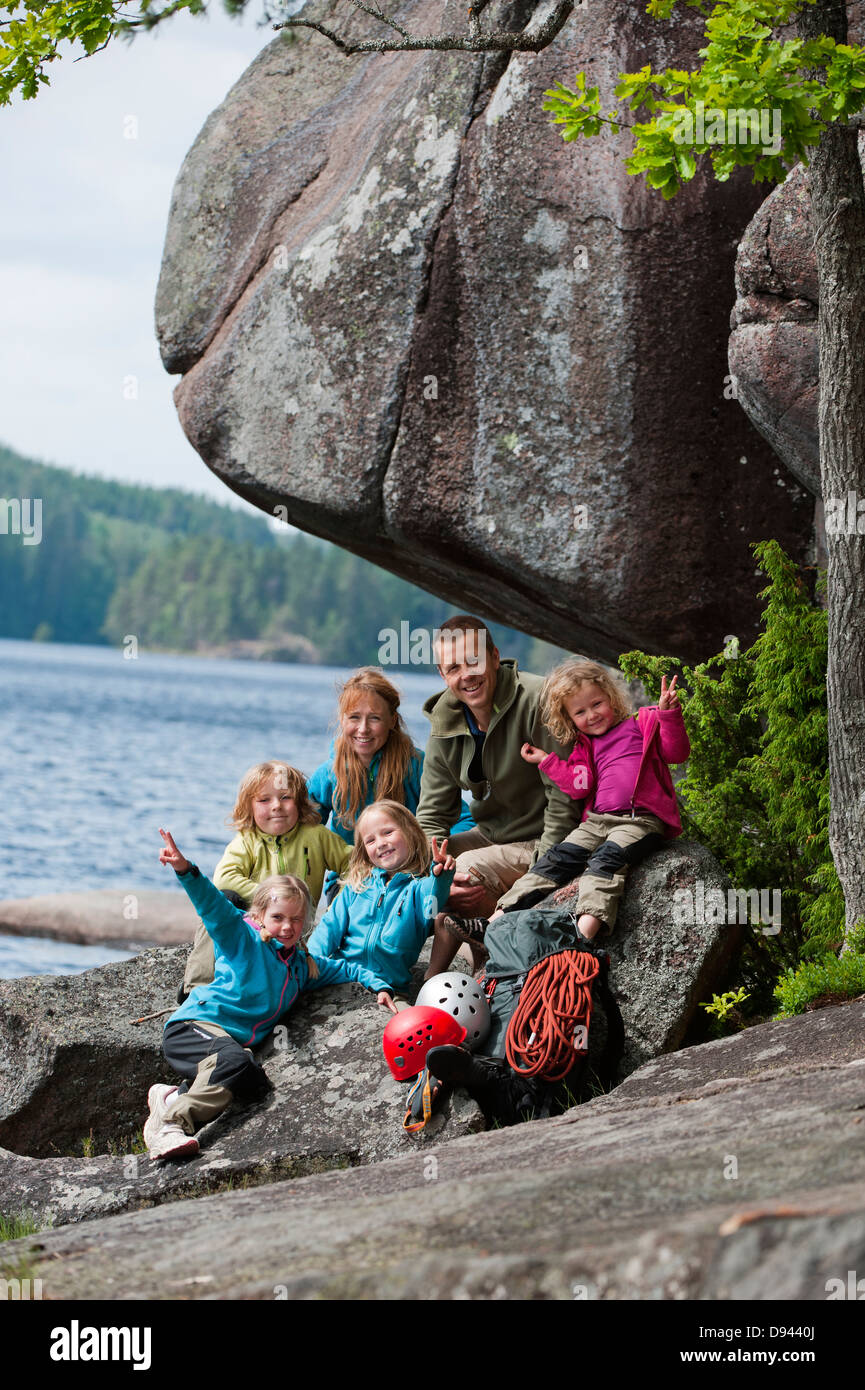 Family with four children sitting near rock with their climbing ...