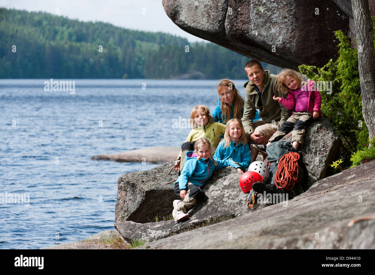 Family with four children sitting near the rock with their climbing ...