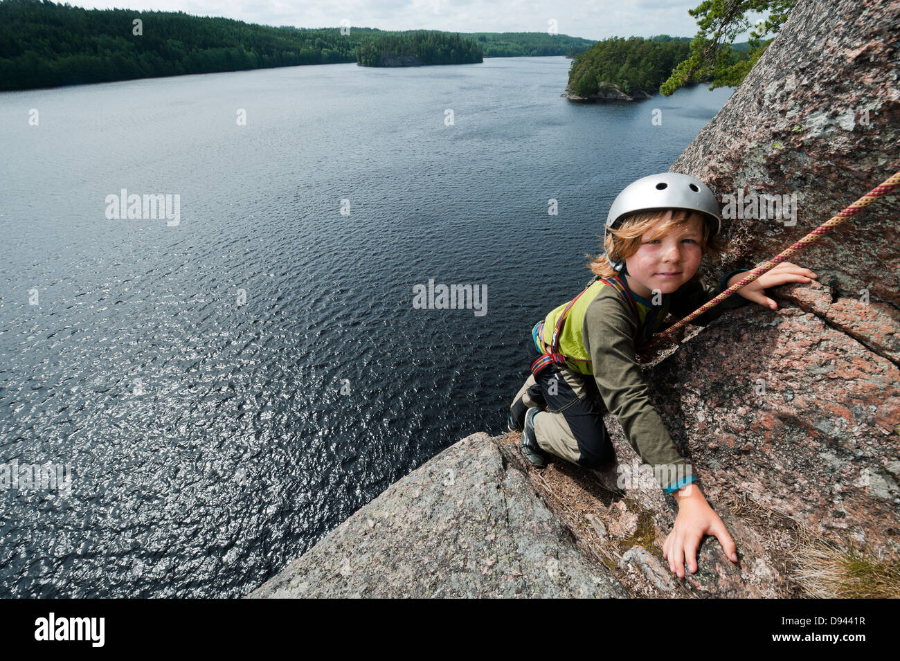 Boy climbing over lake Stock Photo - Alamy