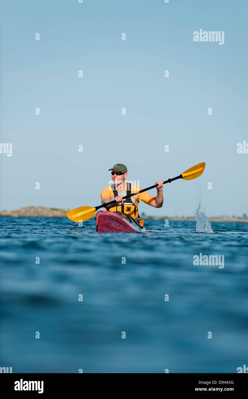 Man kayaking across sea, Sweden Stock Photo - Alamy