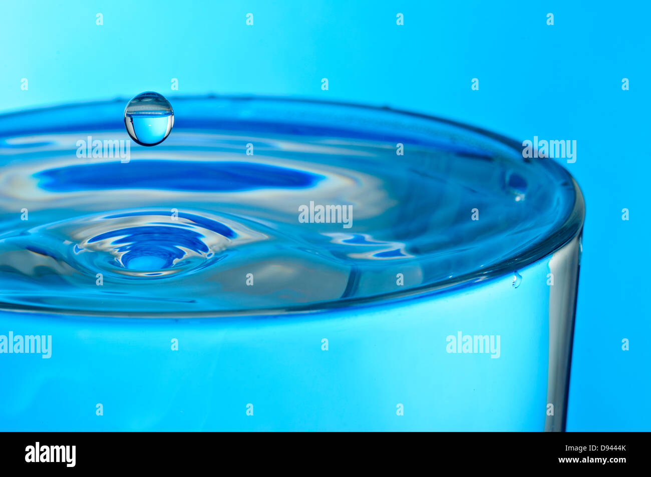Waterdrop falling into glass of water Stock Photo - Alamy