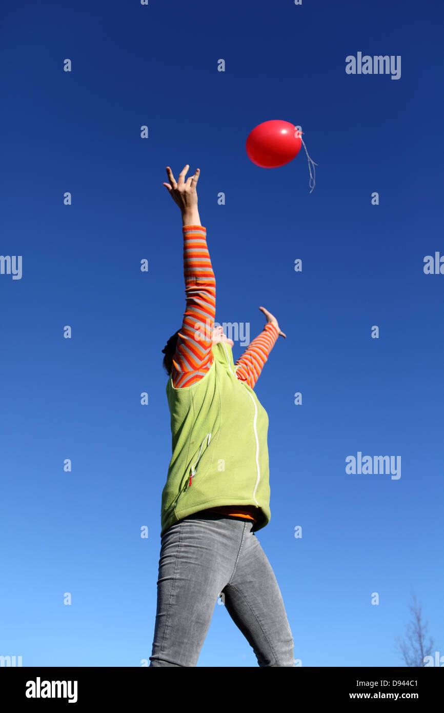 Woman throwing red balloon Stock Photo - Alamy