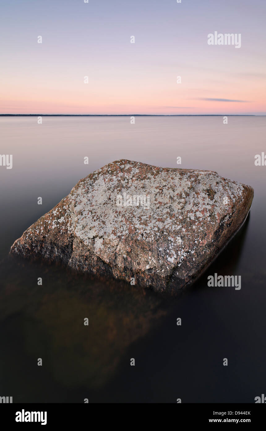 Stone lying in water at sunset Stock Photo - Alamy