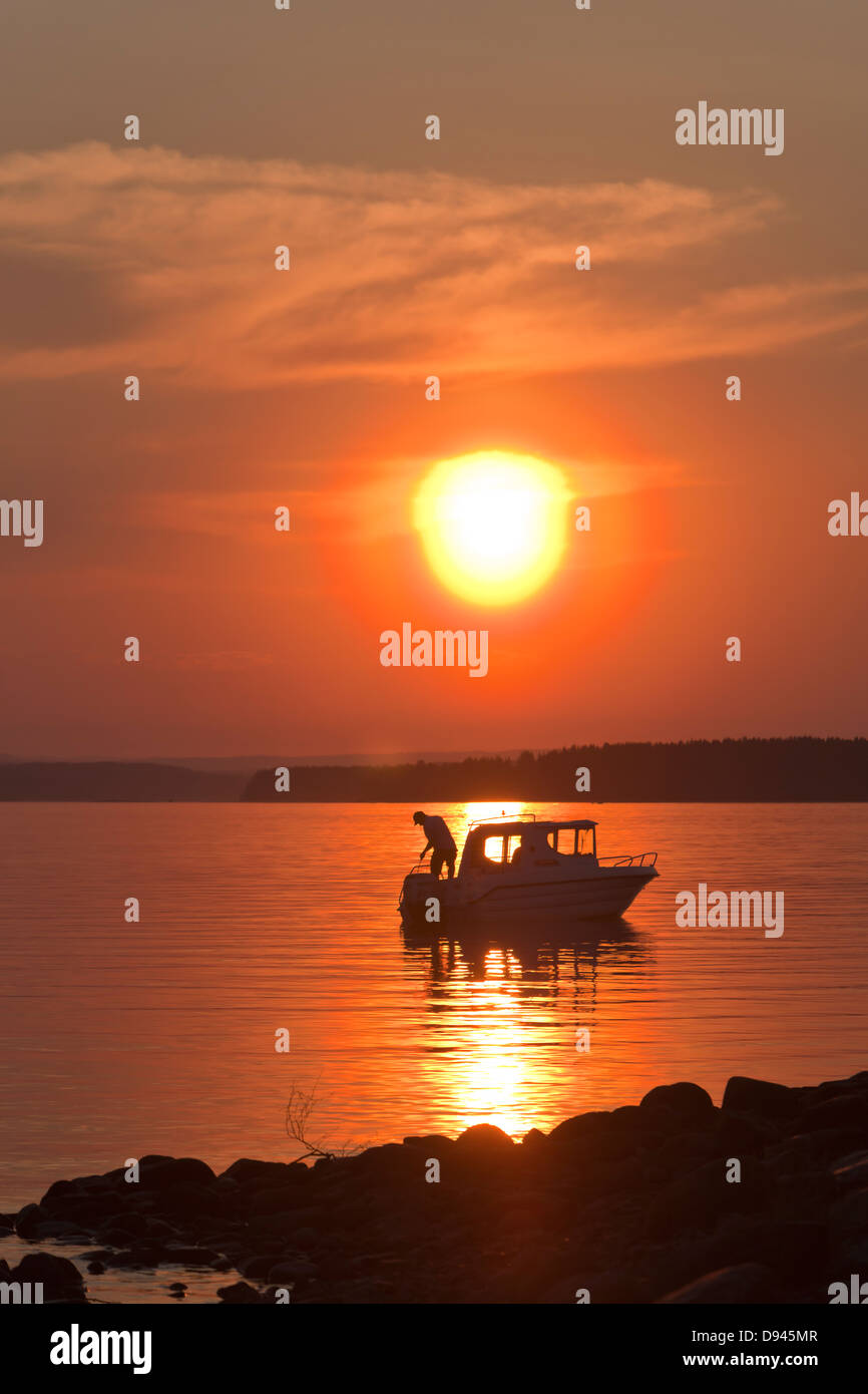 Boat on lake at sunset Stock Photo - Alamy