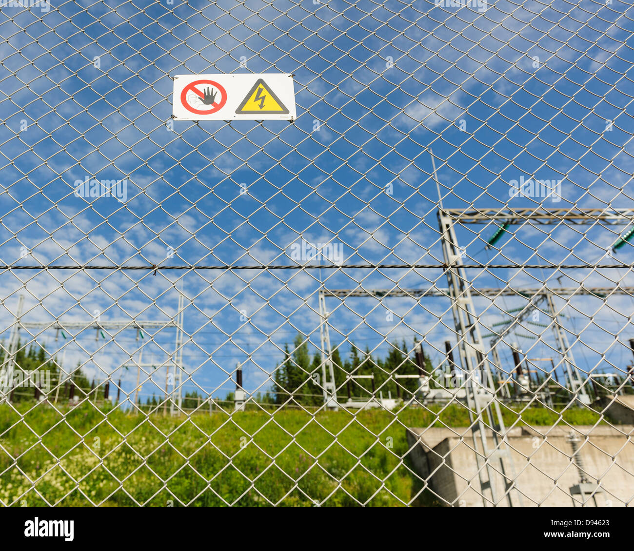 Warning signs on fence around power plant Stock Photo - Alamy