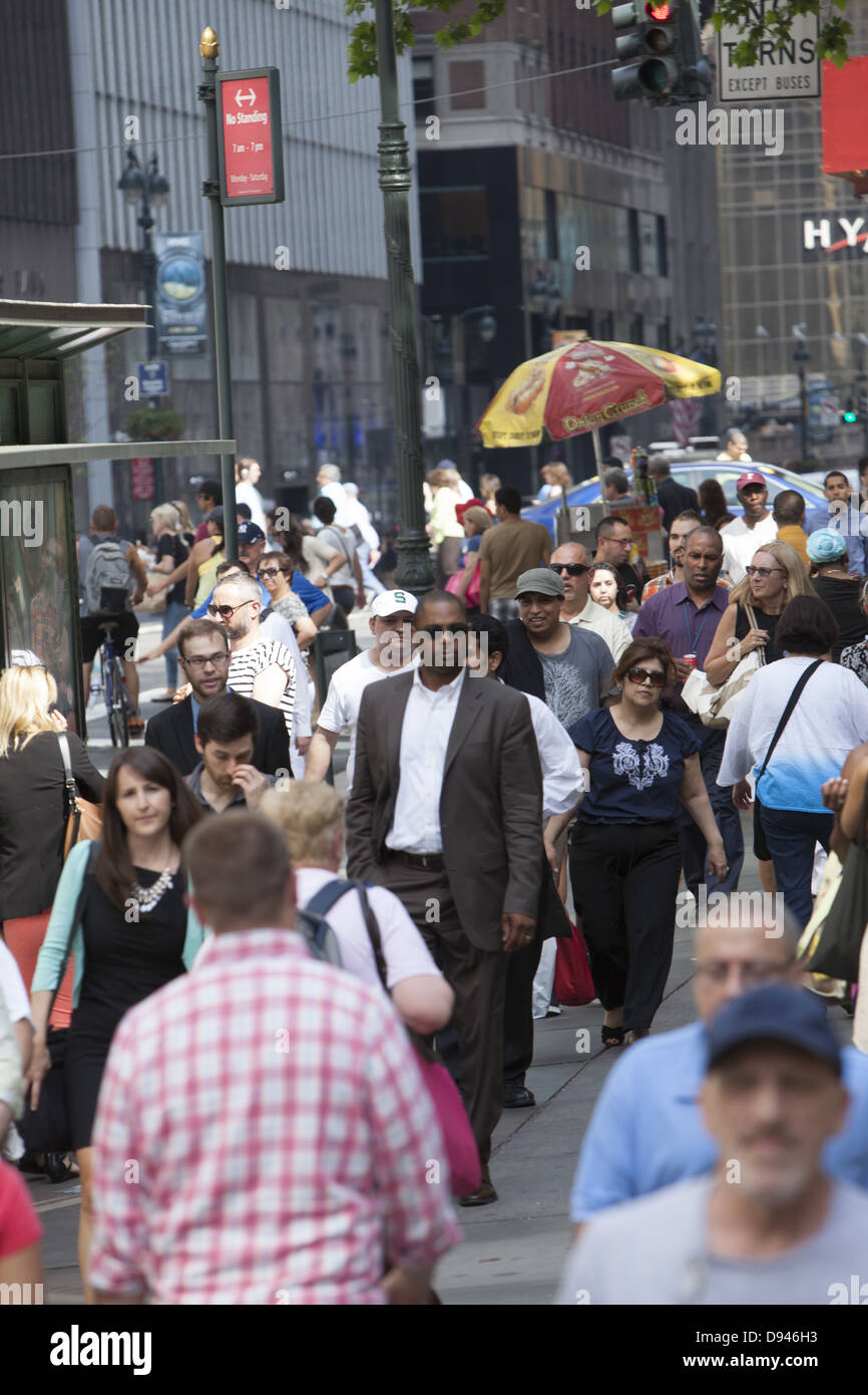 Crowds of tourists walk along 42nd St. by the NY Public library on a ...