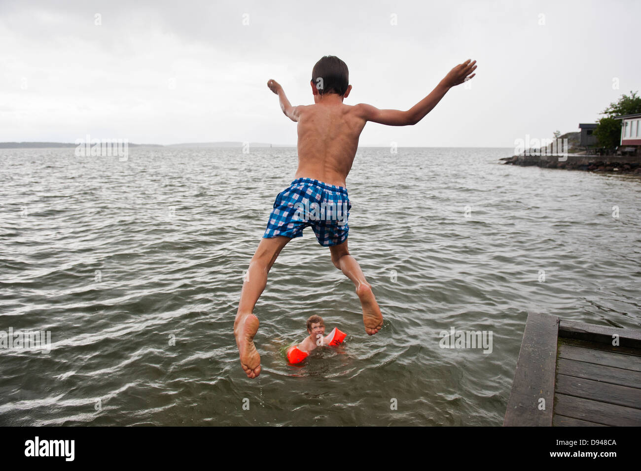 Boy jumping into water Stock Photo - Alamy