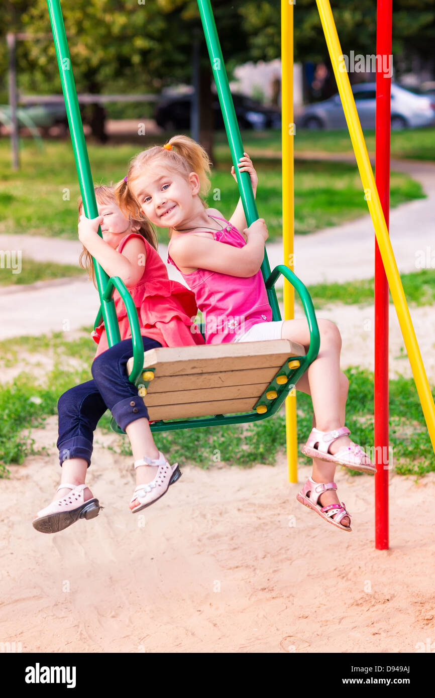 Beautiful little girl on a swings outdoor in the playground at summertime Stock Photo - Alamy