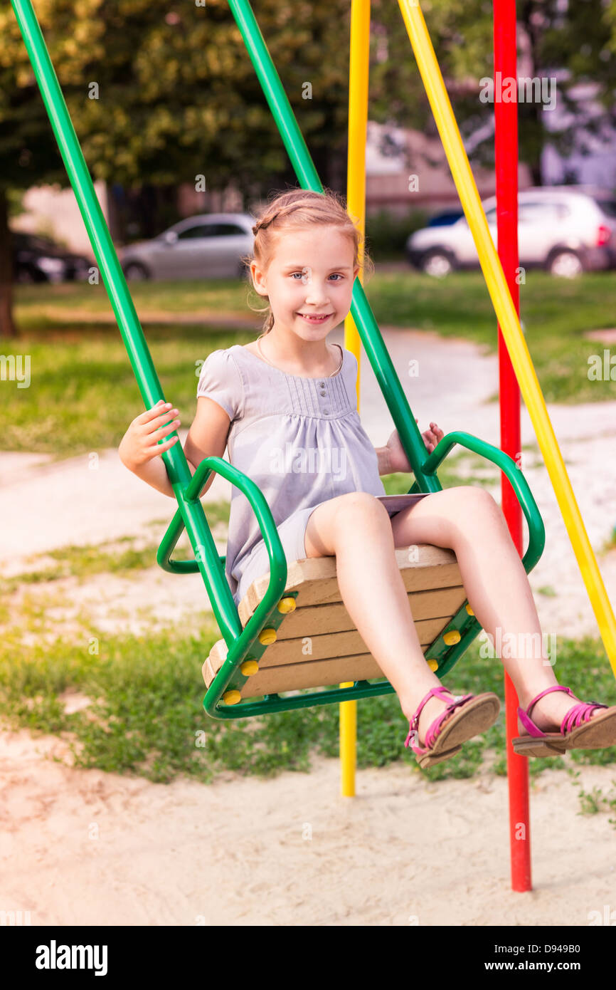 Beautiful little girl on a swings outdoor in the playground at summertime Stock Photo - Alamy