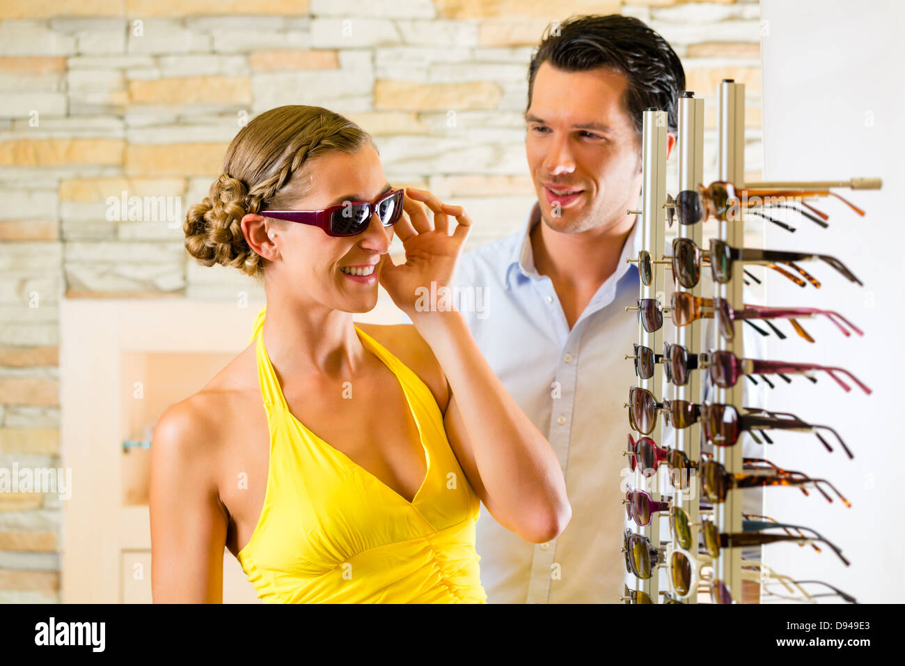 Young woman at optician with glasses, they are looking for sunglasses ...
