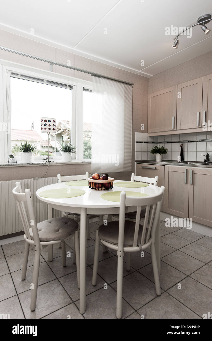 White kitchen with dining table Stock Photo - Alamy