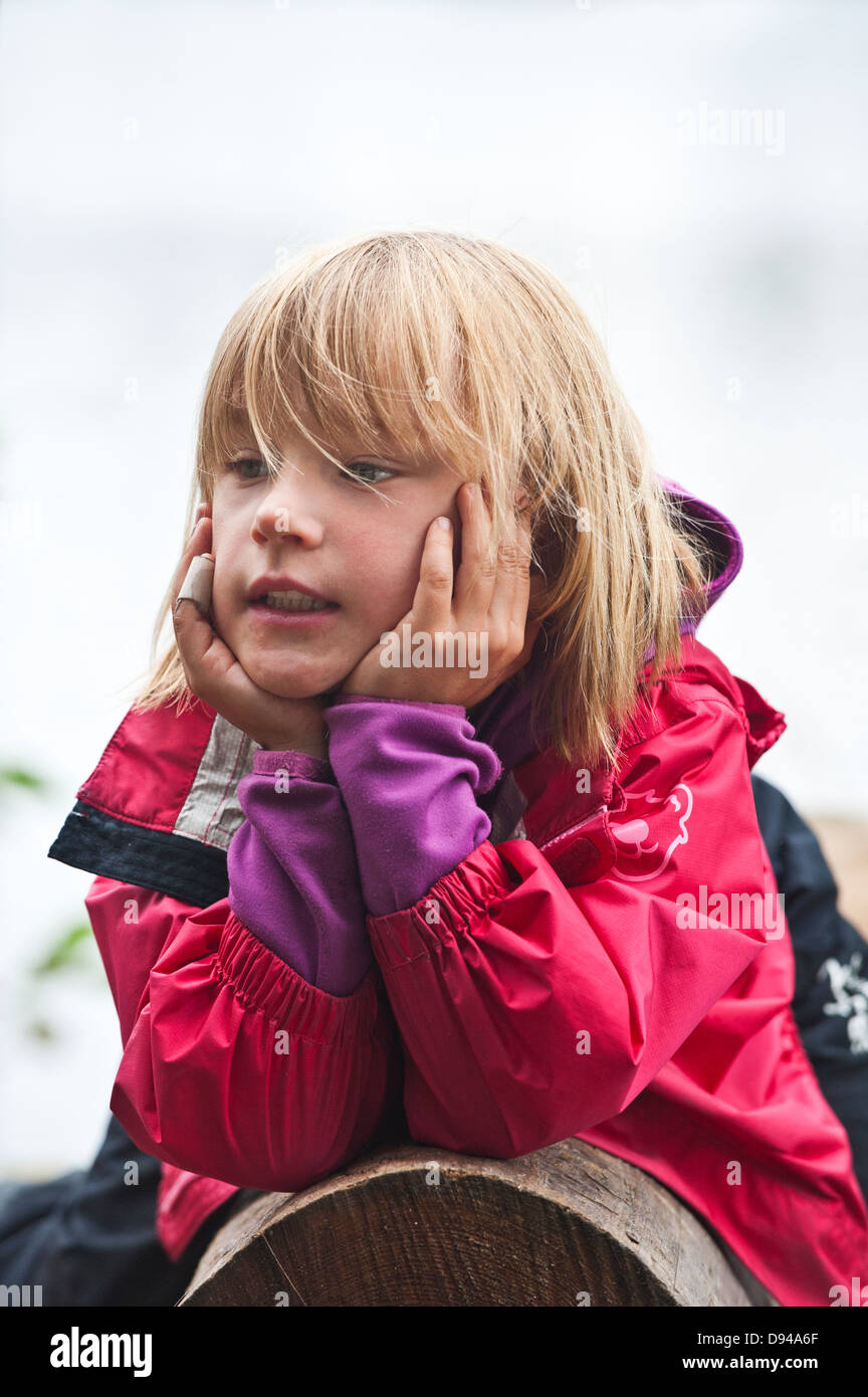 Girl leaning on log Stock Photo - Alamy