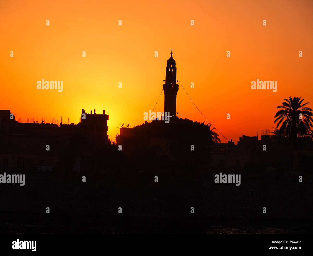 Mosque and skyline in silhouette at sunset on the River Nile, Egypt ...
