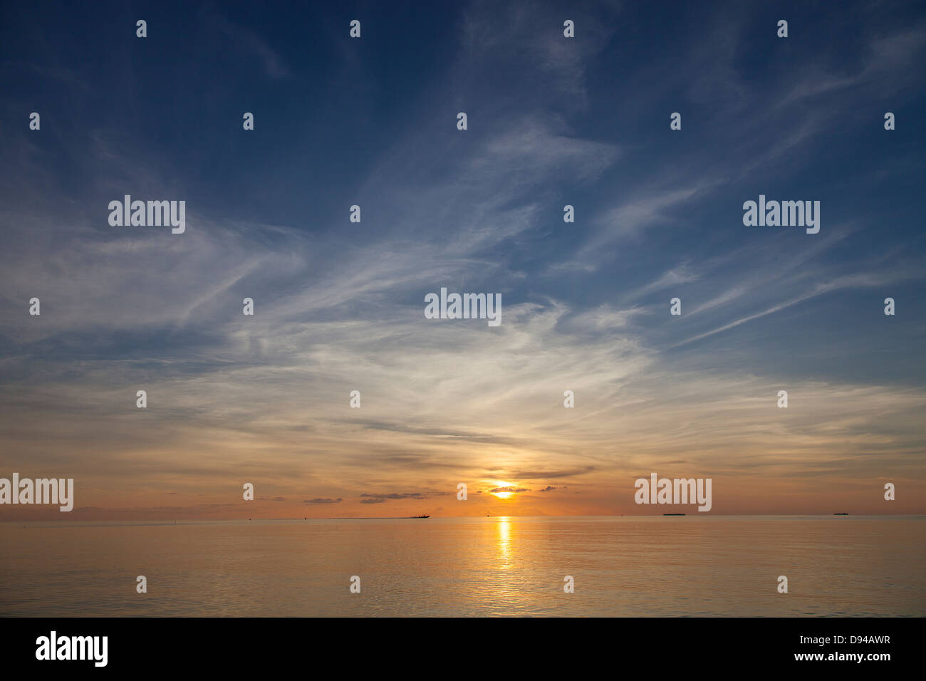 Sun setting over sea Stock Photo - Alamy