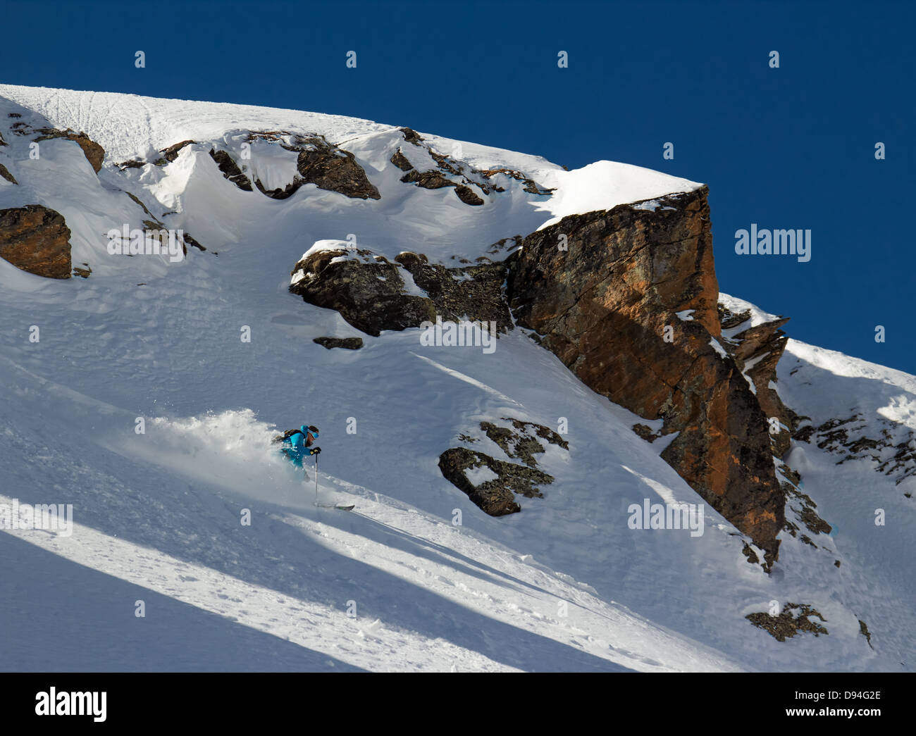 Woman skier in deep snow on a steep slope in the area of rocks Stock ...