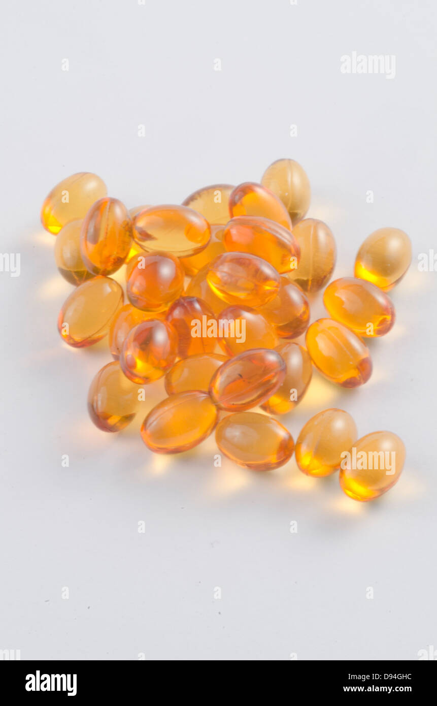 Medical capsules with golden colour and liquid Stock Photo - Alamy