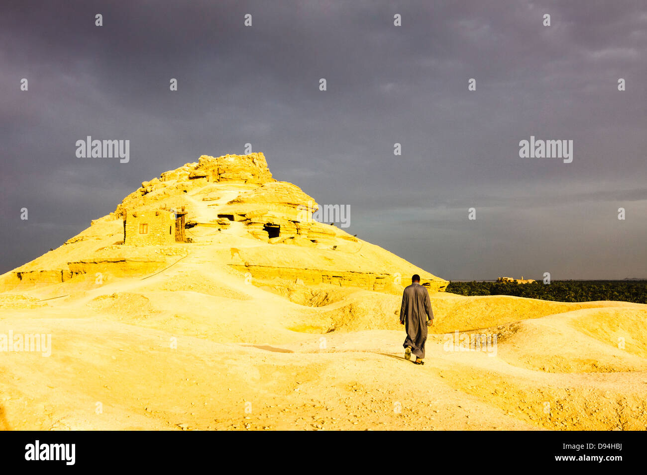 Siwa oasis, Egypt. Egyptian man walking by the Ptolemaic and Roman ...