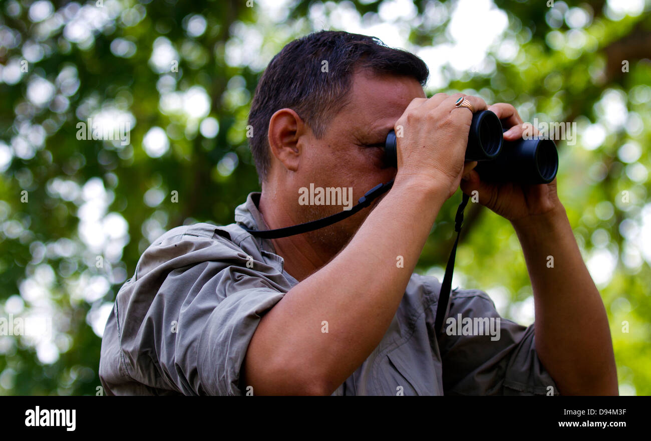 Young explorer looking through binoculars Stock Photo - Alamy