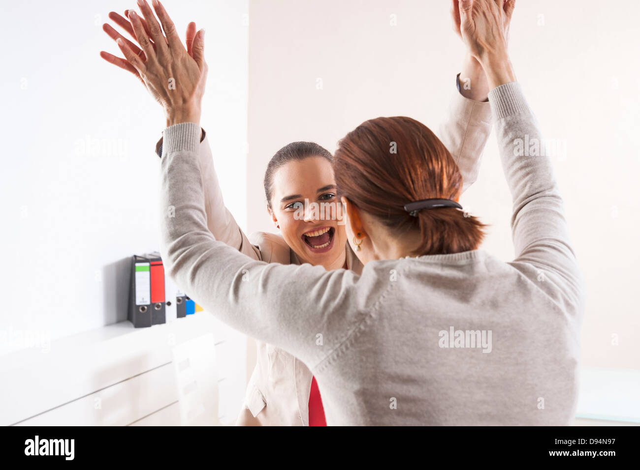 Businesswomen Cheering in Office Stock Photo - Alamy