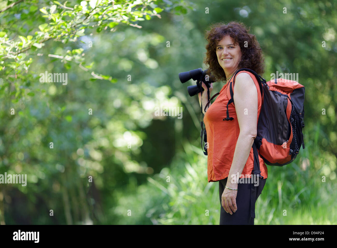 Middle aged woman observing wildlife with binoculars Stock Photo - Alamy