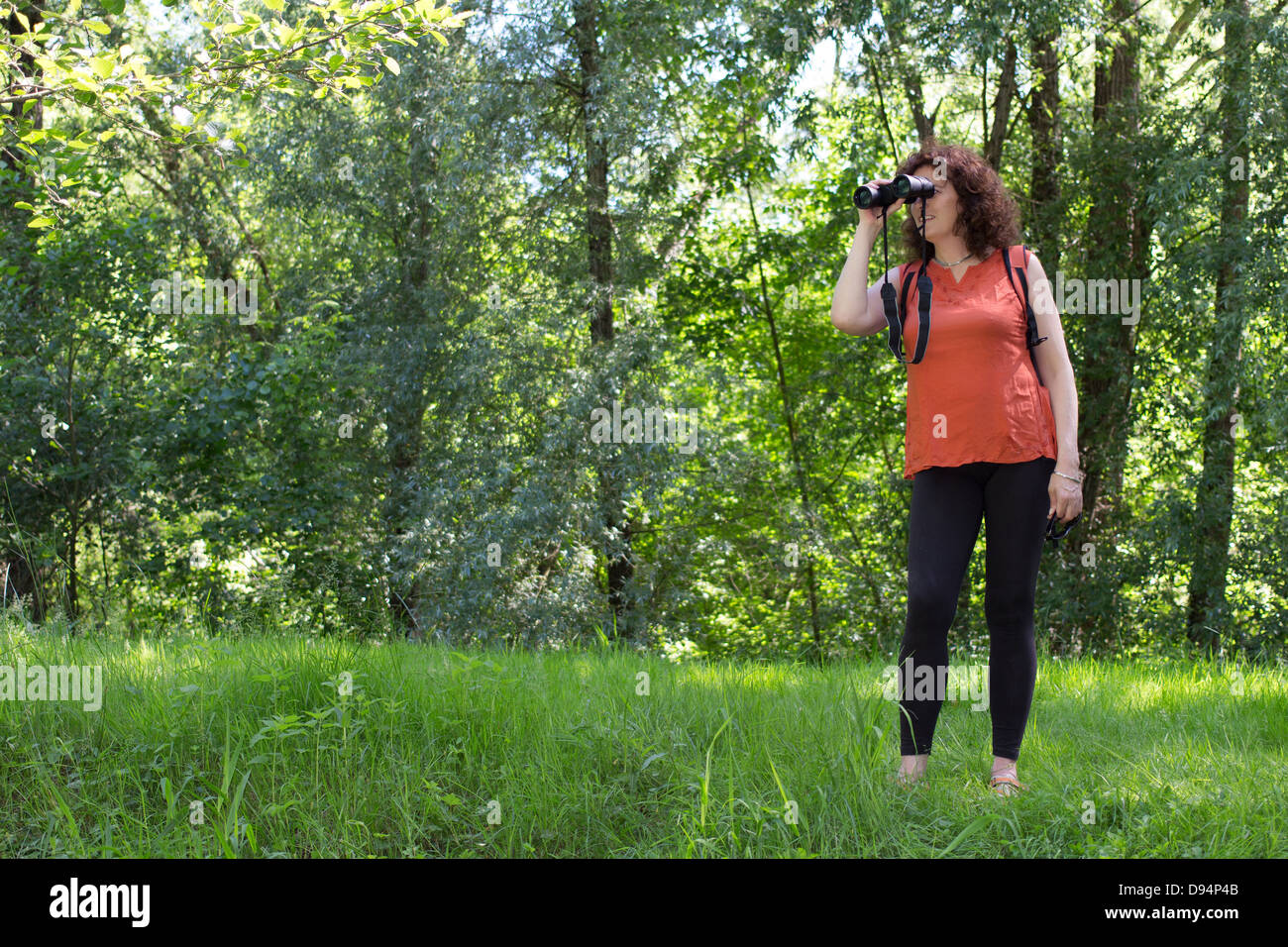 Middle aged woman observing wildlife with binoculars Stock Photo - Alamy