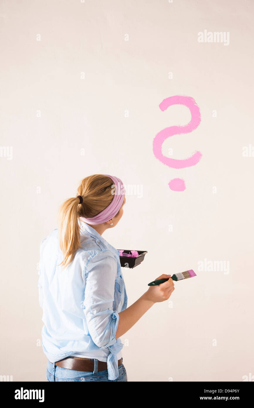 Studio Shot of Young Woman Painting a Question Mark on a Wall Stock ...