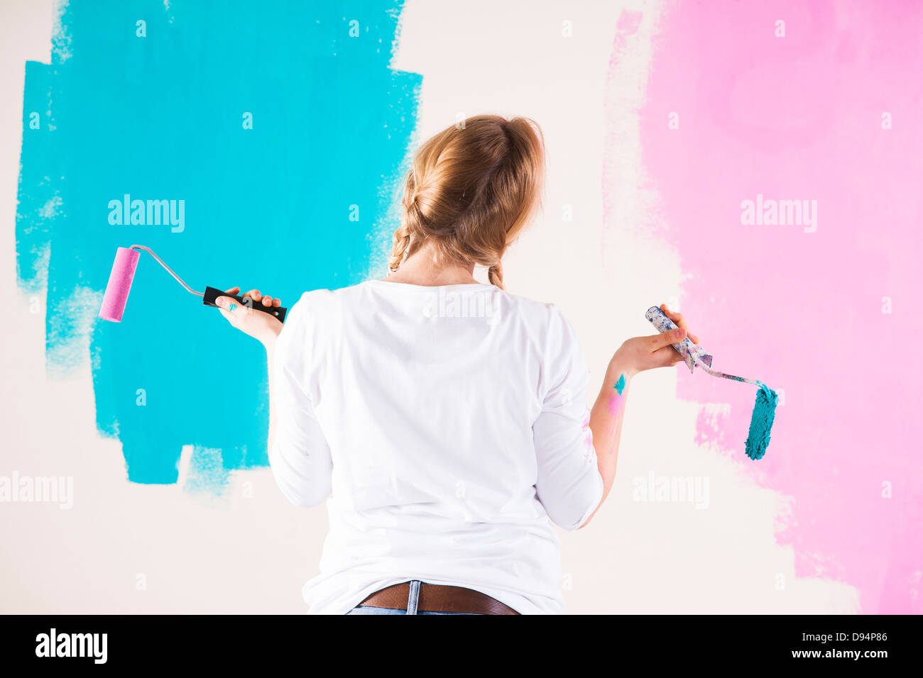 Studio Shot of Young Woman Holding Paint Rollers, Deciding Between ...