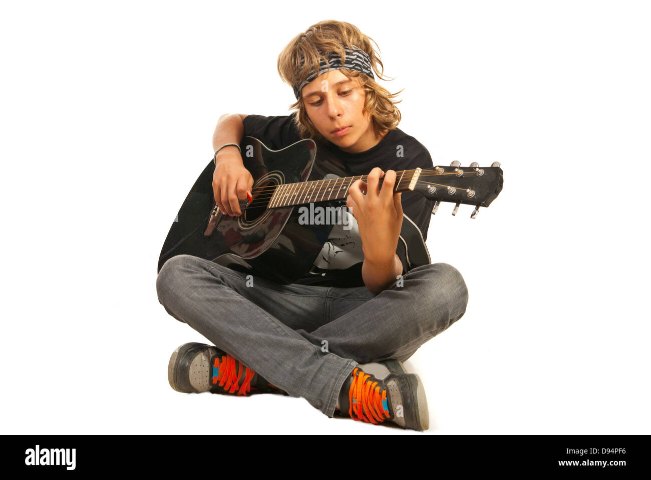 Rocker teen with bandana playing acoustic guitar isolated on white ...