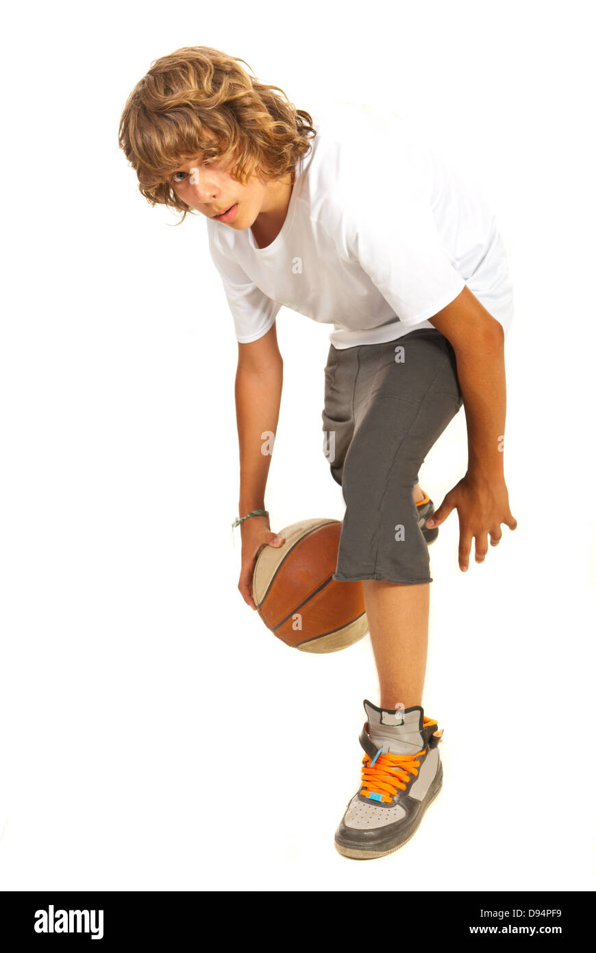 Young boy dribbling basketball isolated on white background Stock Photo ...