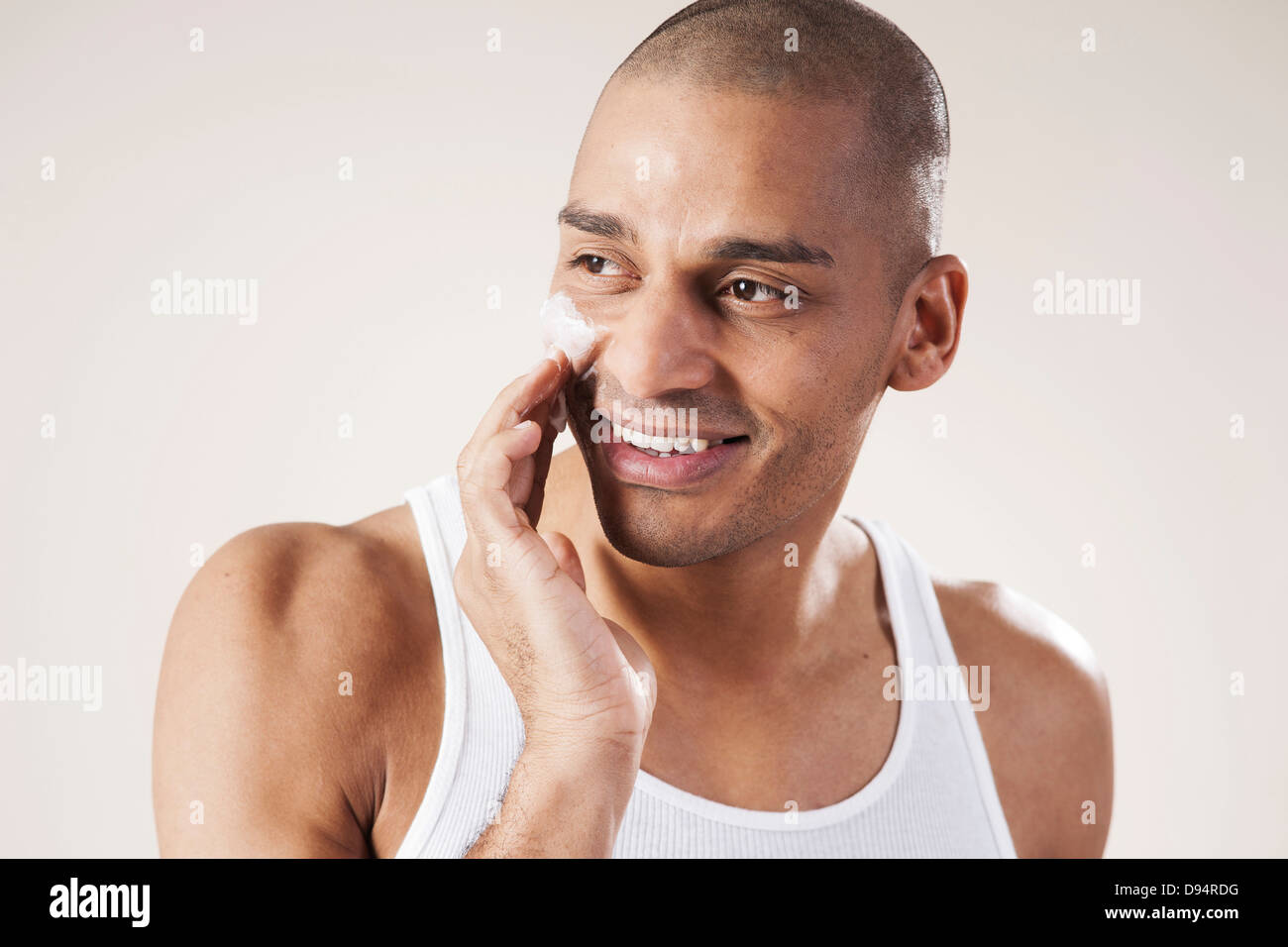 Man Applying Lotion to his Face in Studio with White Background Stock Photo - Alamy