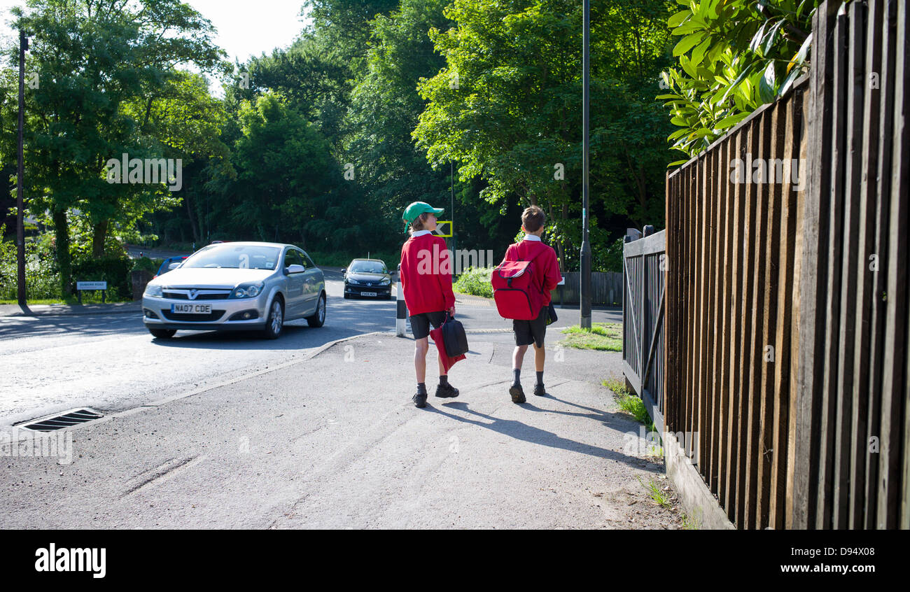 two young boys walk to school along busy road Stock Photo - Alamy