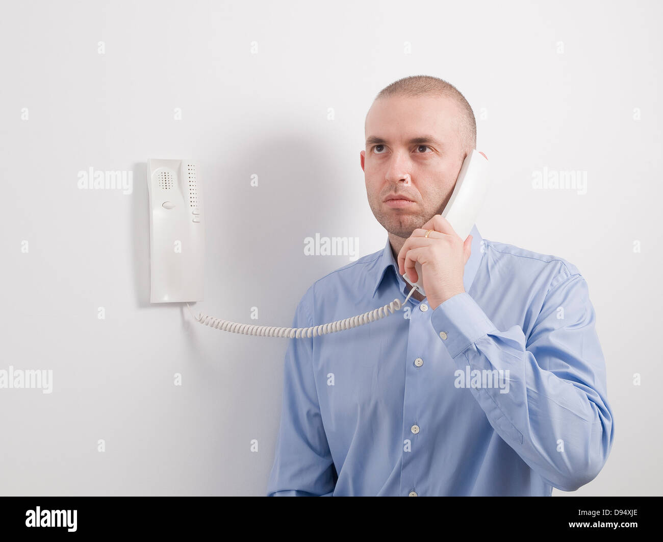 Caucasian man holding an intercom on a white wall Stock Photo - Alamy