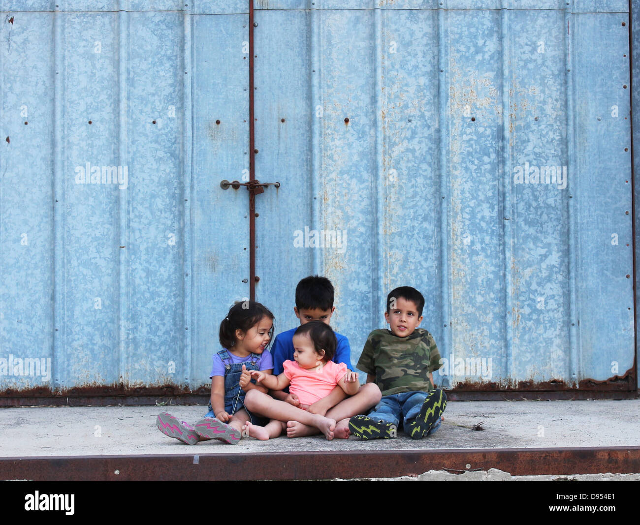 Four children rest by a huge barn Stock Photo - Alamy